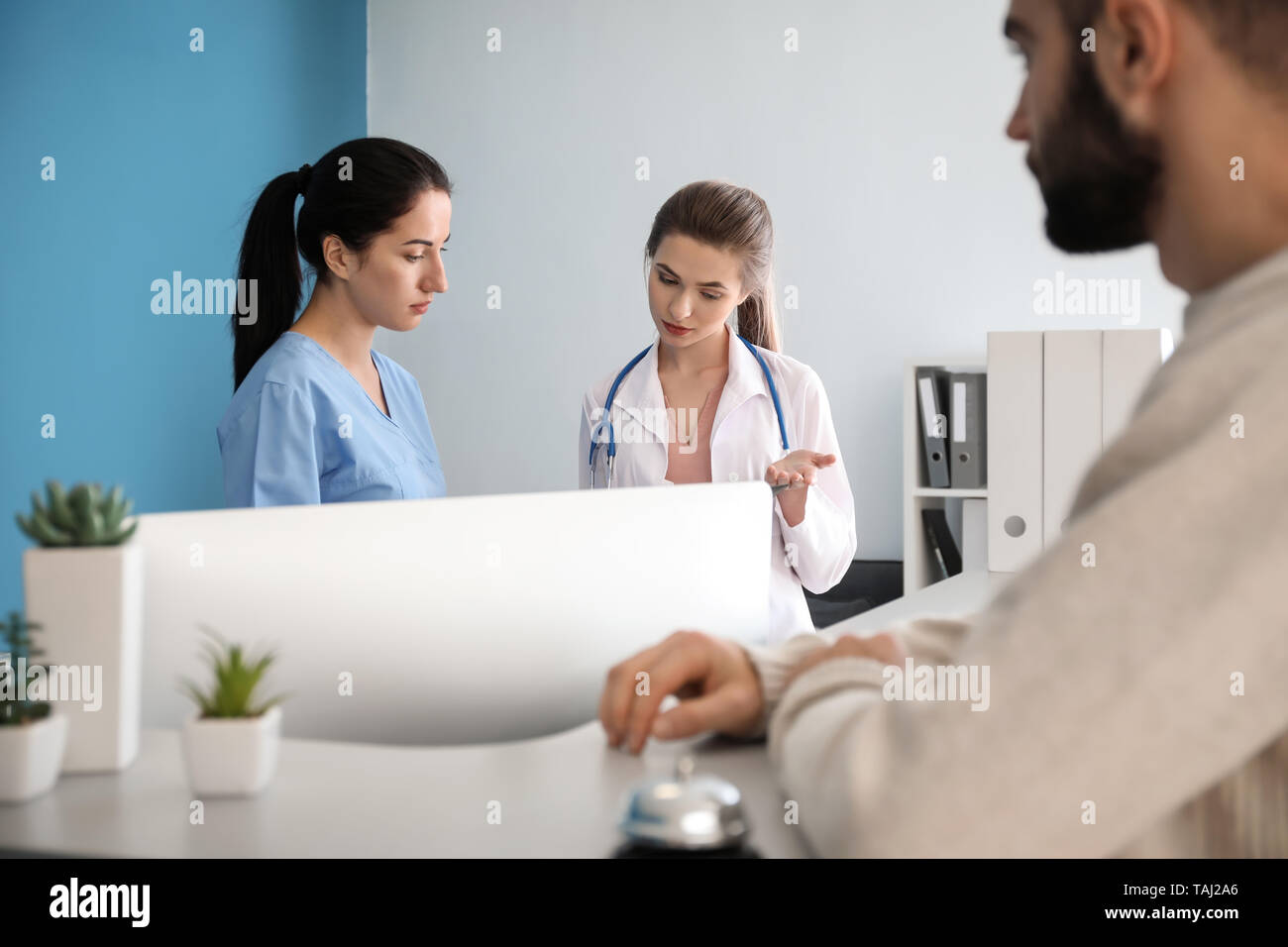 Patient waiting at reception desk in clinic Stock Photo - Alamy