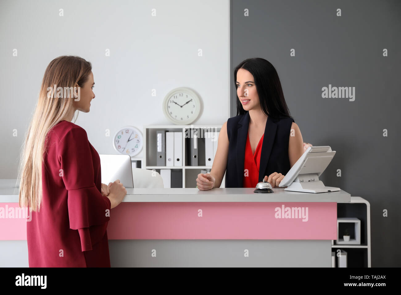 Young woman near reception desk in hotel Stock Photo - Alamy