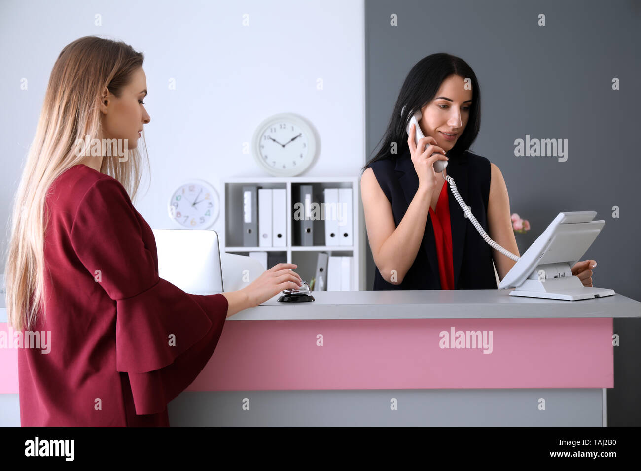 Young woman near reception desk in hotel Stock Photo - Alamy