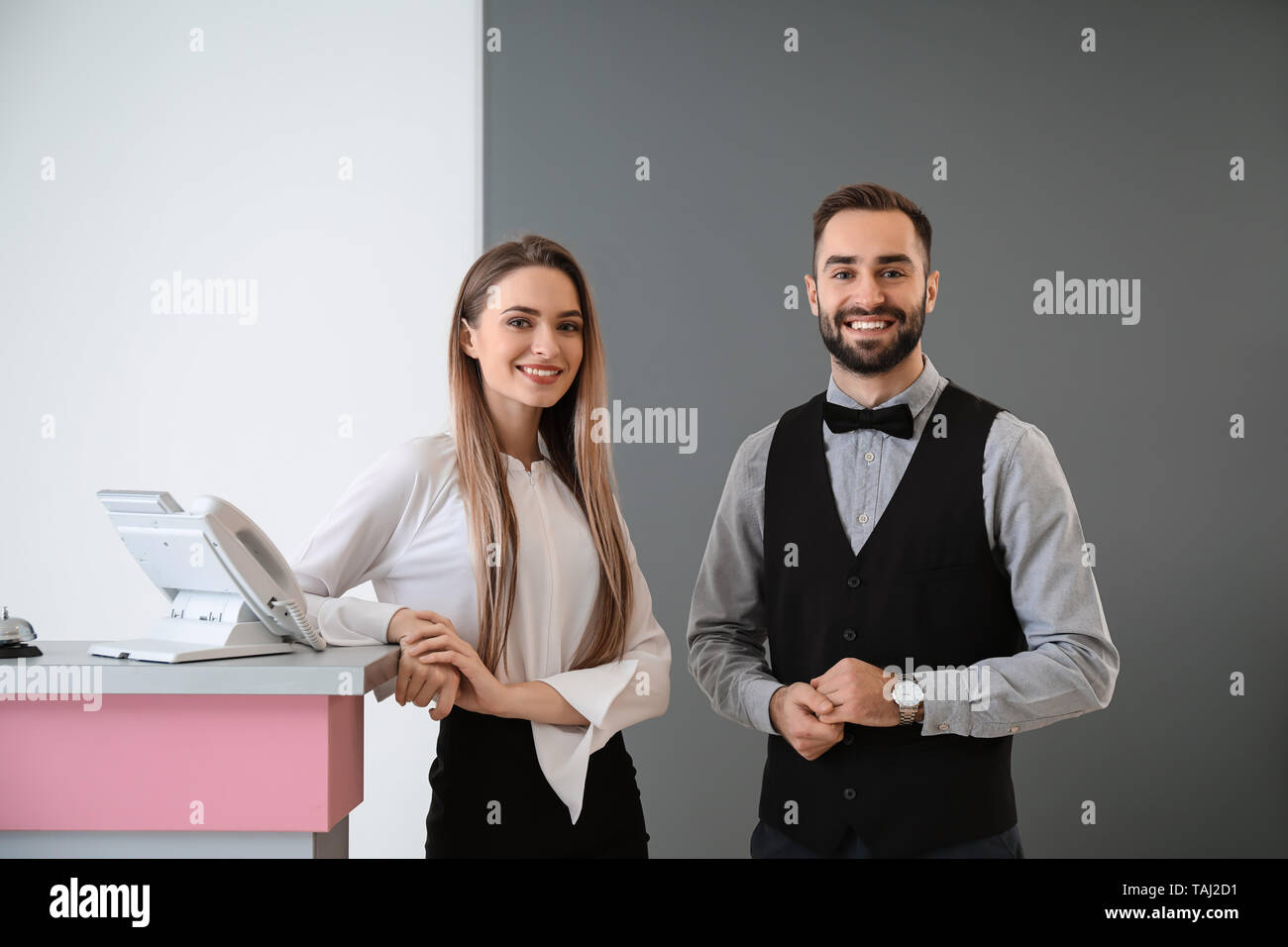 Male and female receptionists near desk in hotel Stock Photo - Alamy