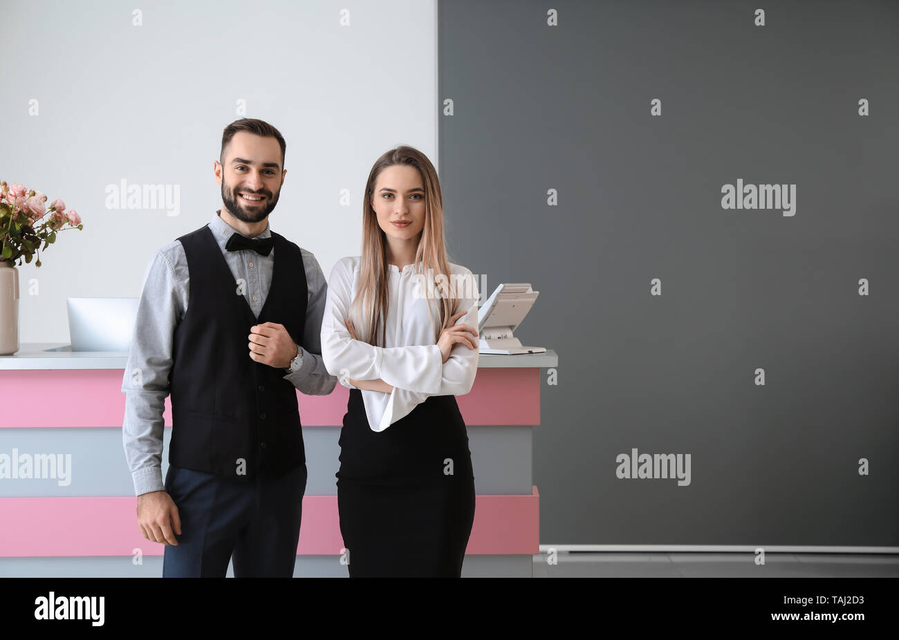 Male and female receptionists near desk in hotel Stock Photo - Alamy