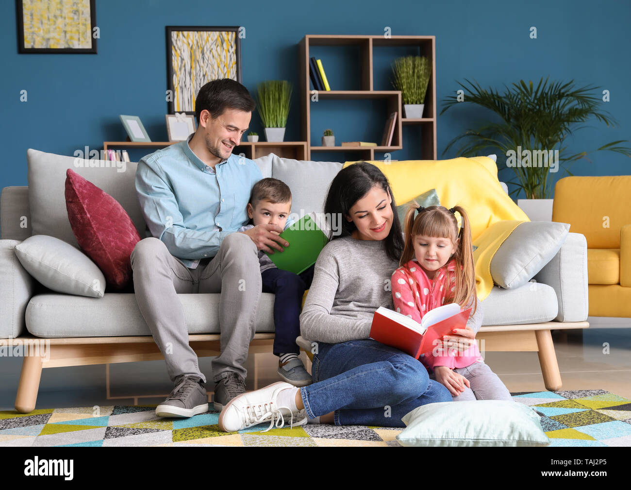 Happy family reading books at home Stock Photo - Alamy