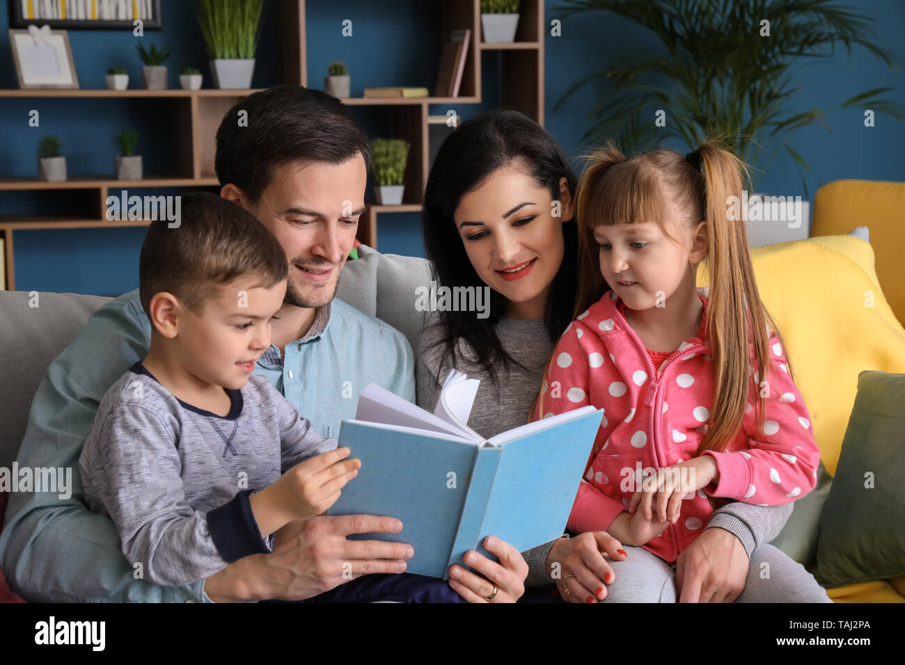 Happy family reading book at home Stock Photo - Alamy