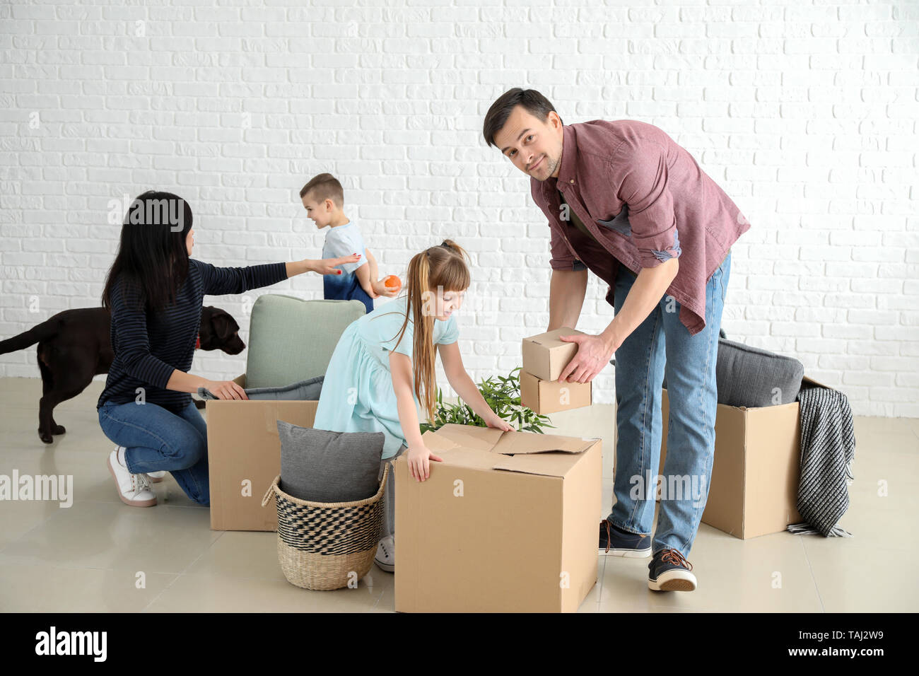 Family unpacking things after moving into new house Stock Photo - Alamy