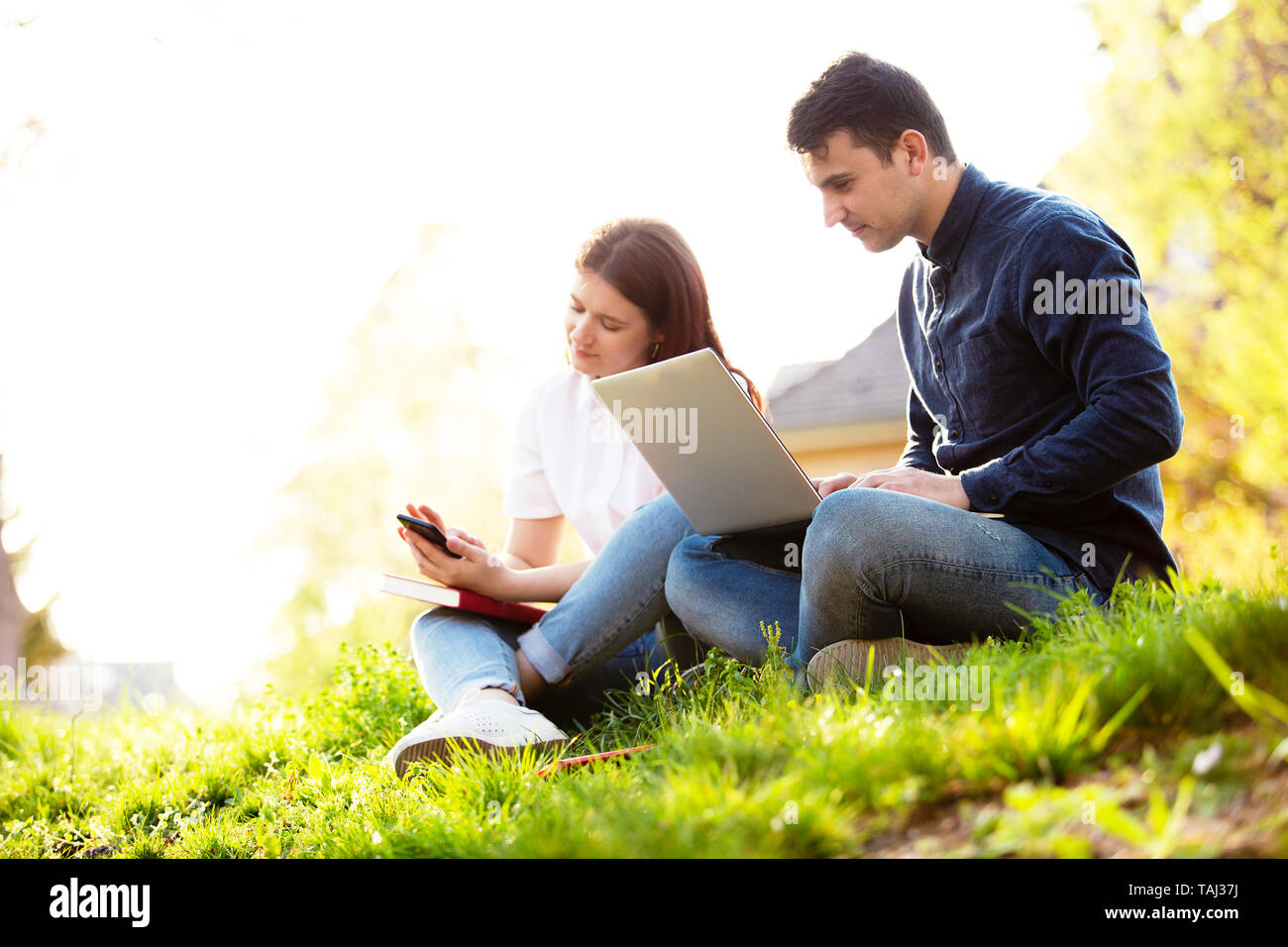 Students using laptop and mobile phone learning for exam together in a ...