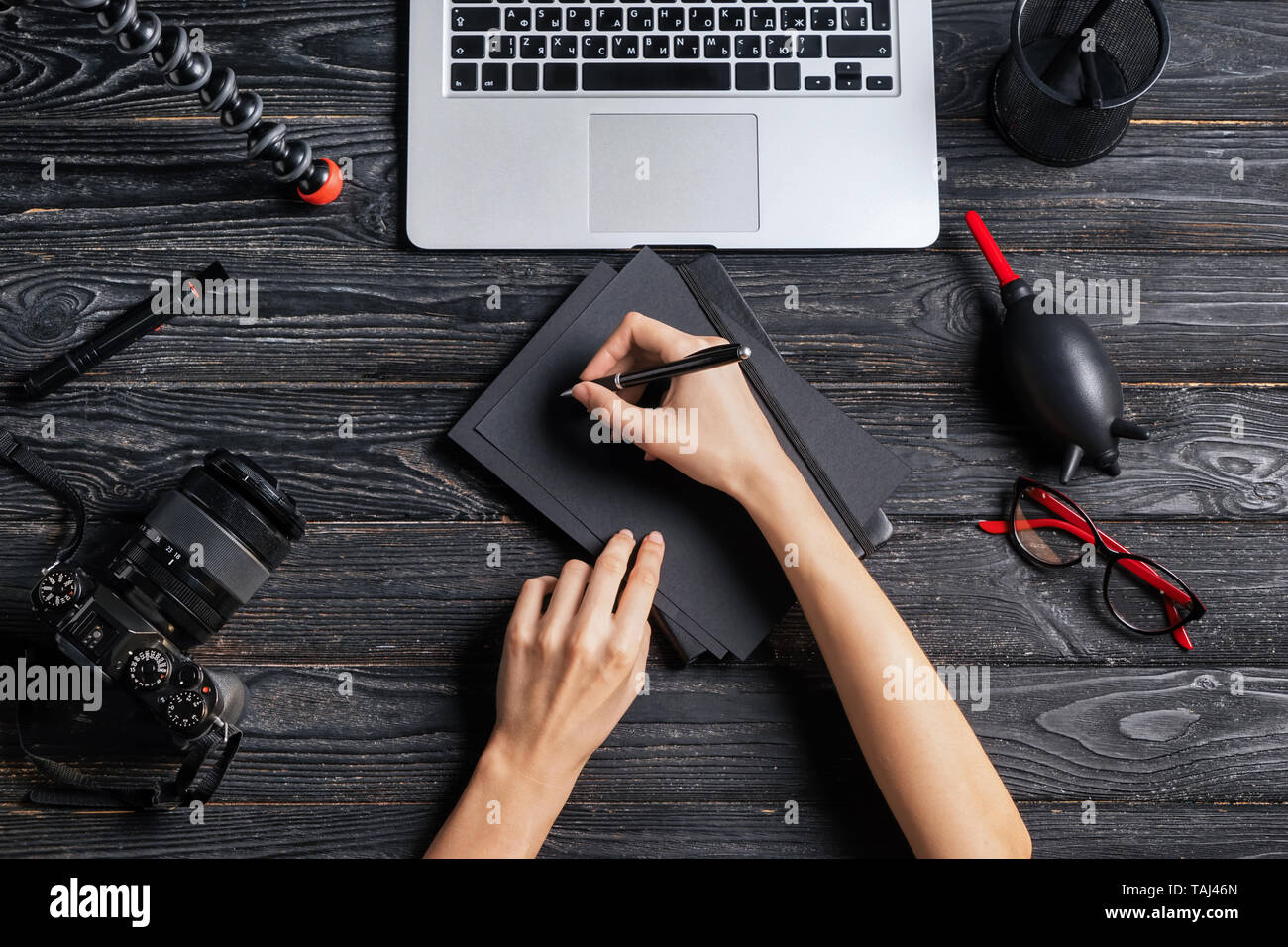 Female photographer writing in notebook at table, top view Stock Photo ...