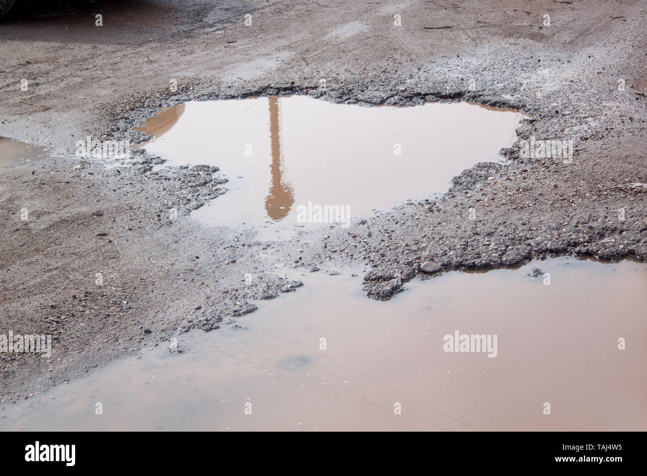 Dangerous destroyed roadbed. The bad asphalted road. Big pothole filled ...
