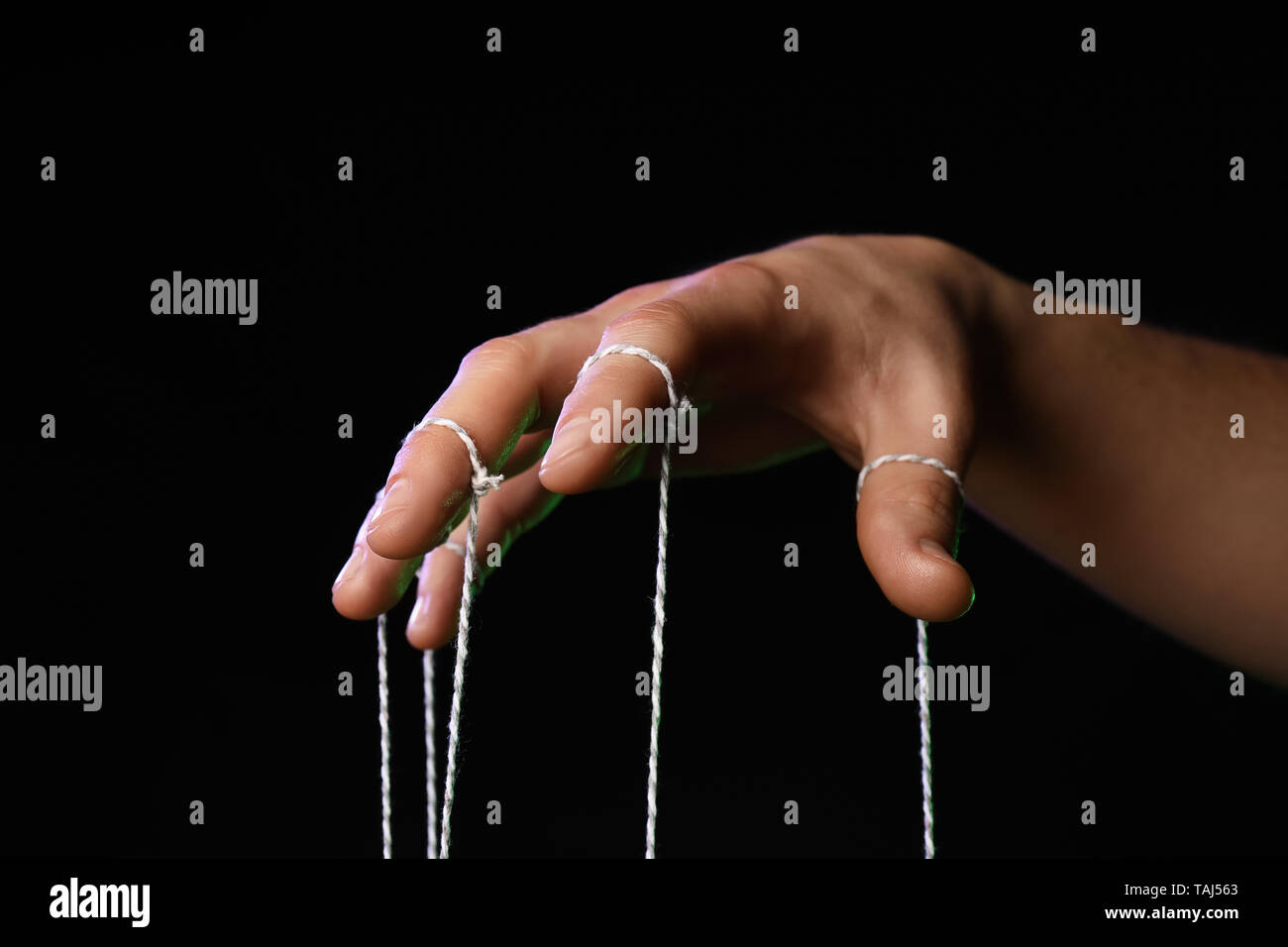 Hand of puppeteer on dark background Stock Photo - Alamy