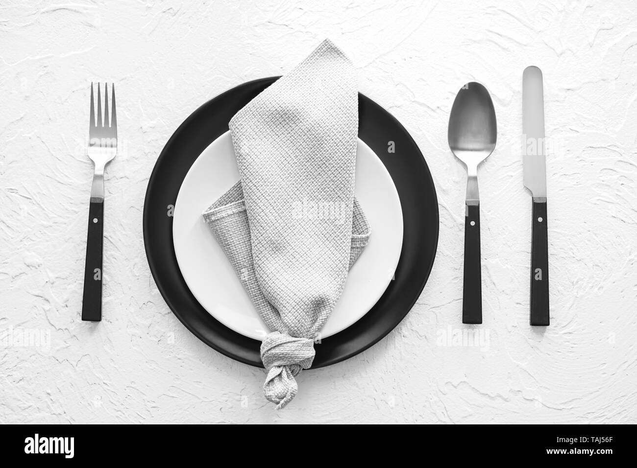 Simple table setting on white textured background Stock Photo - Alamy