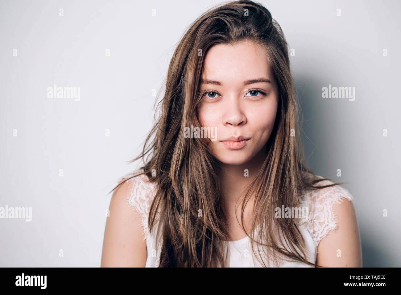 Close up portrait of the beautiful young sly woman on the white ...
