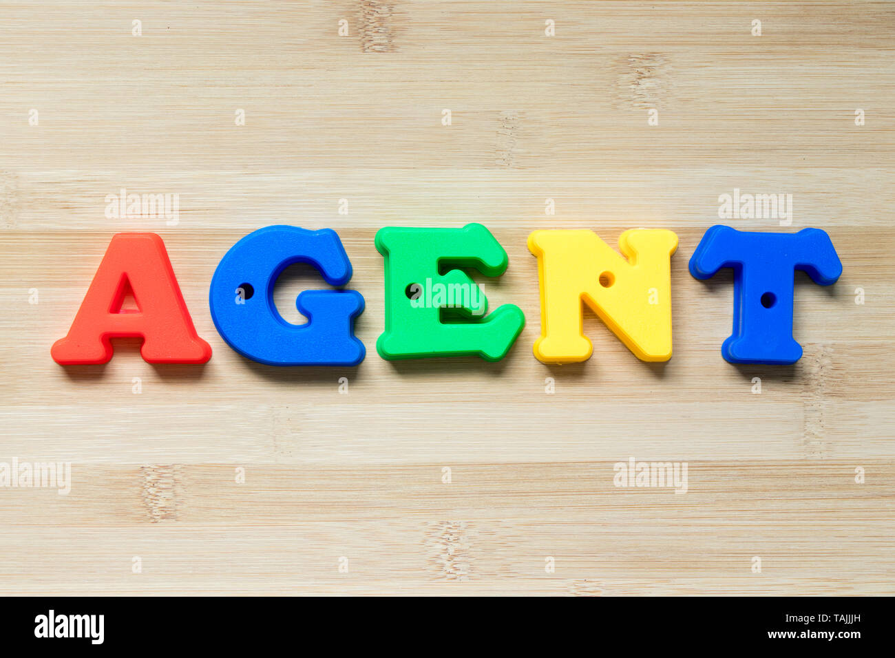 Color plastic alphabet in word agent on wood background Stock Photo - Alamy