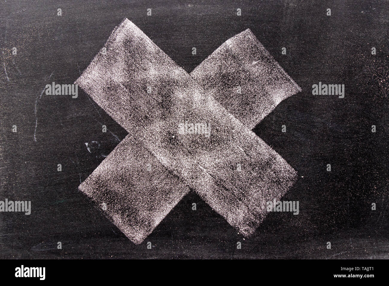 White color chak hand drawing in cross or x shape on blackboard ...