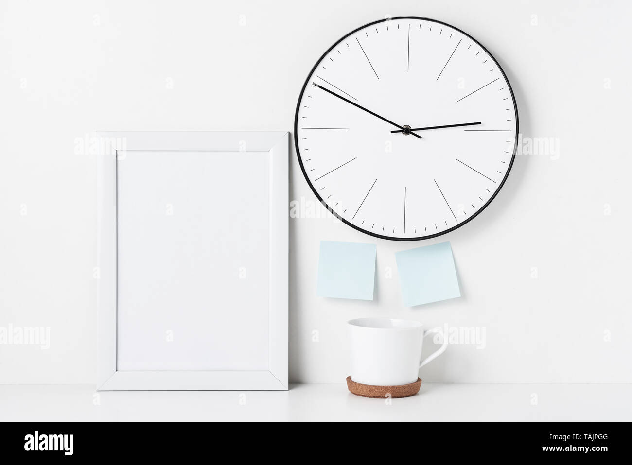 Mock up empty frame, round wall clock, two stickers and cup on white ...