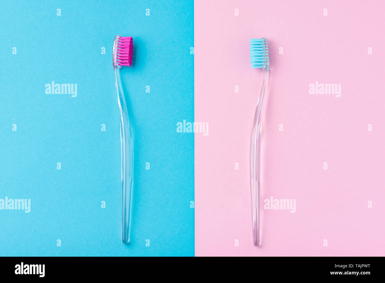 Two plastic toothbrushes on pastel blue and pink background, flat lay ...