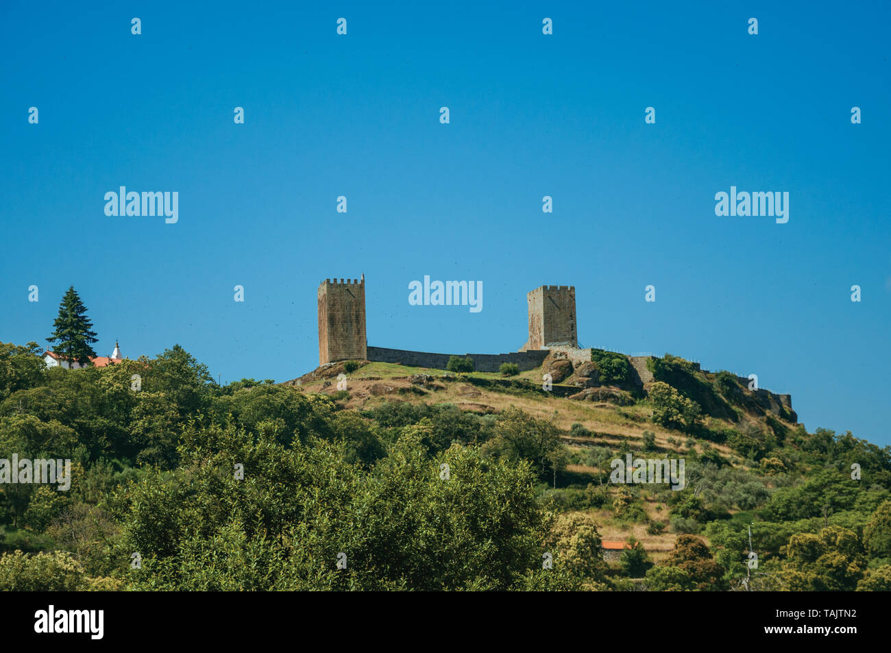 Hilly landscape with trees and rocks and the towers of Linhares da ...
