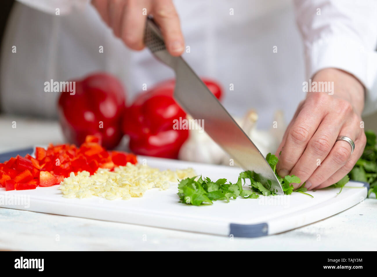 Chef's hand cutting or chopping coriander Stock Photo - Alamy