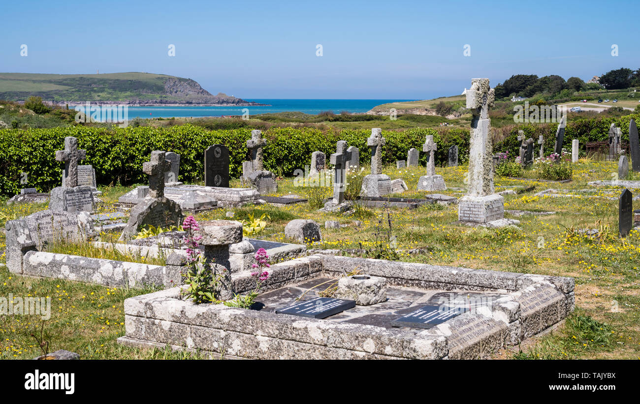 The churchyard at St. Enodoc's Church with the sea and Daymer Bay in ...