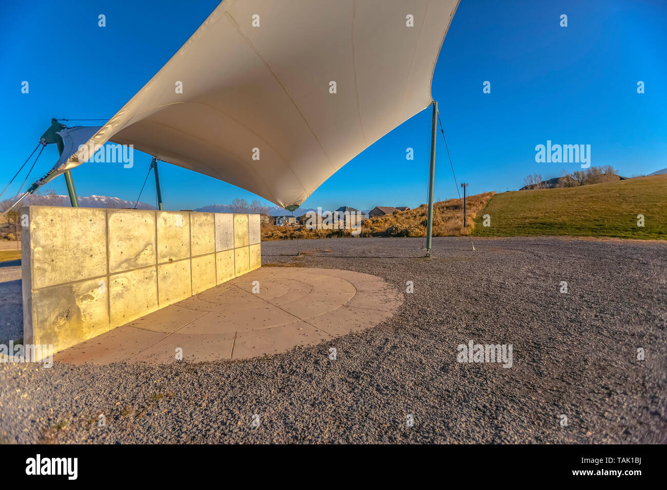 Concrete rectangular structure on a rocky ground under a white canopy ...