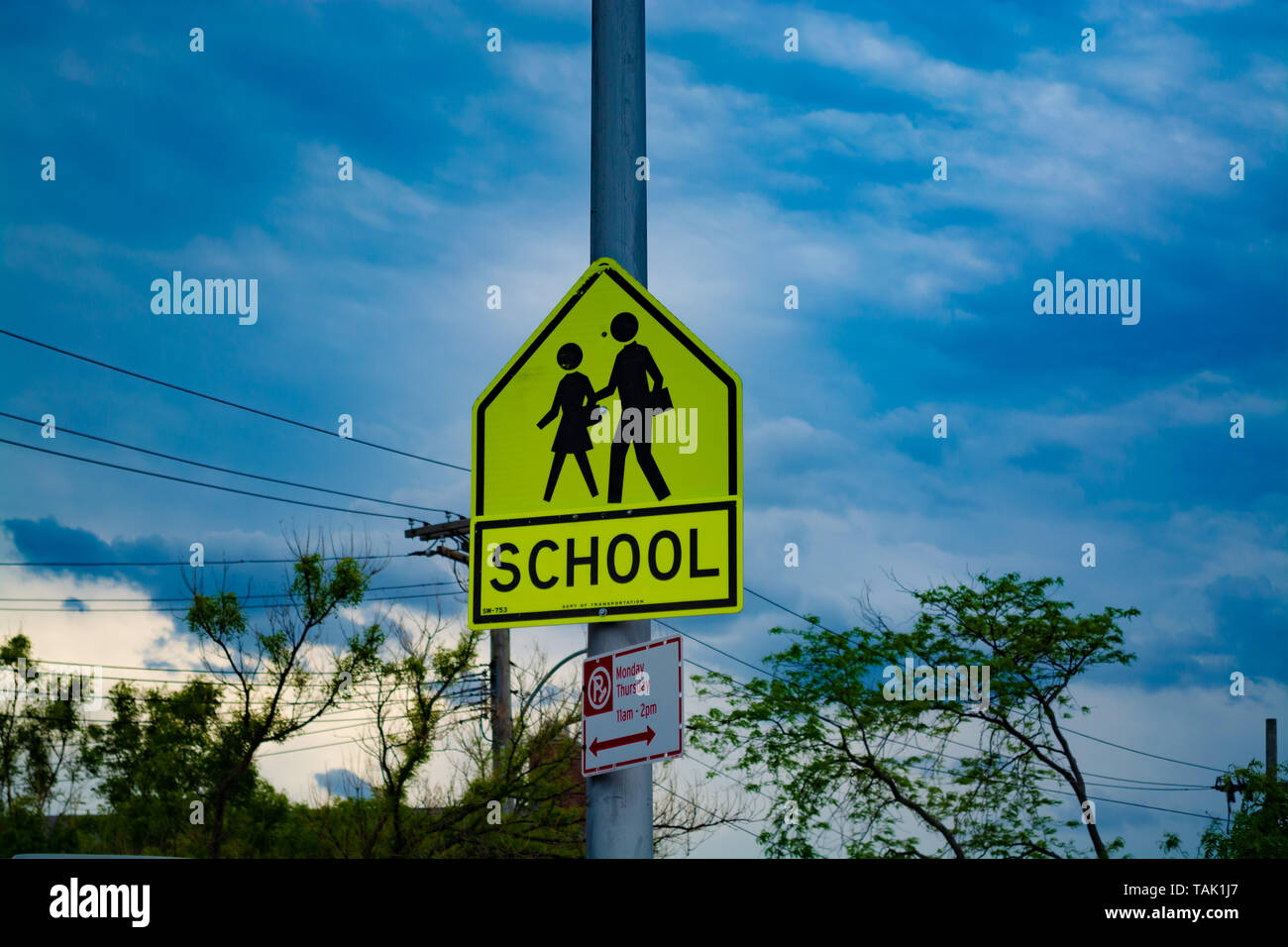 School sign and blue cloudy sky Stock Photo - Alamy