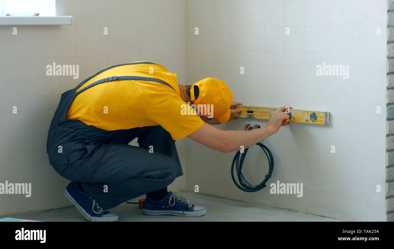 Young constructor checking wall level hi-res stock photography and ...