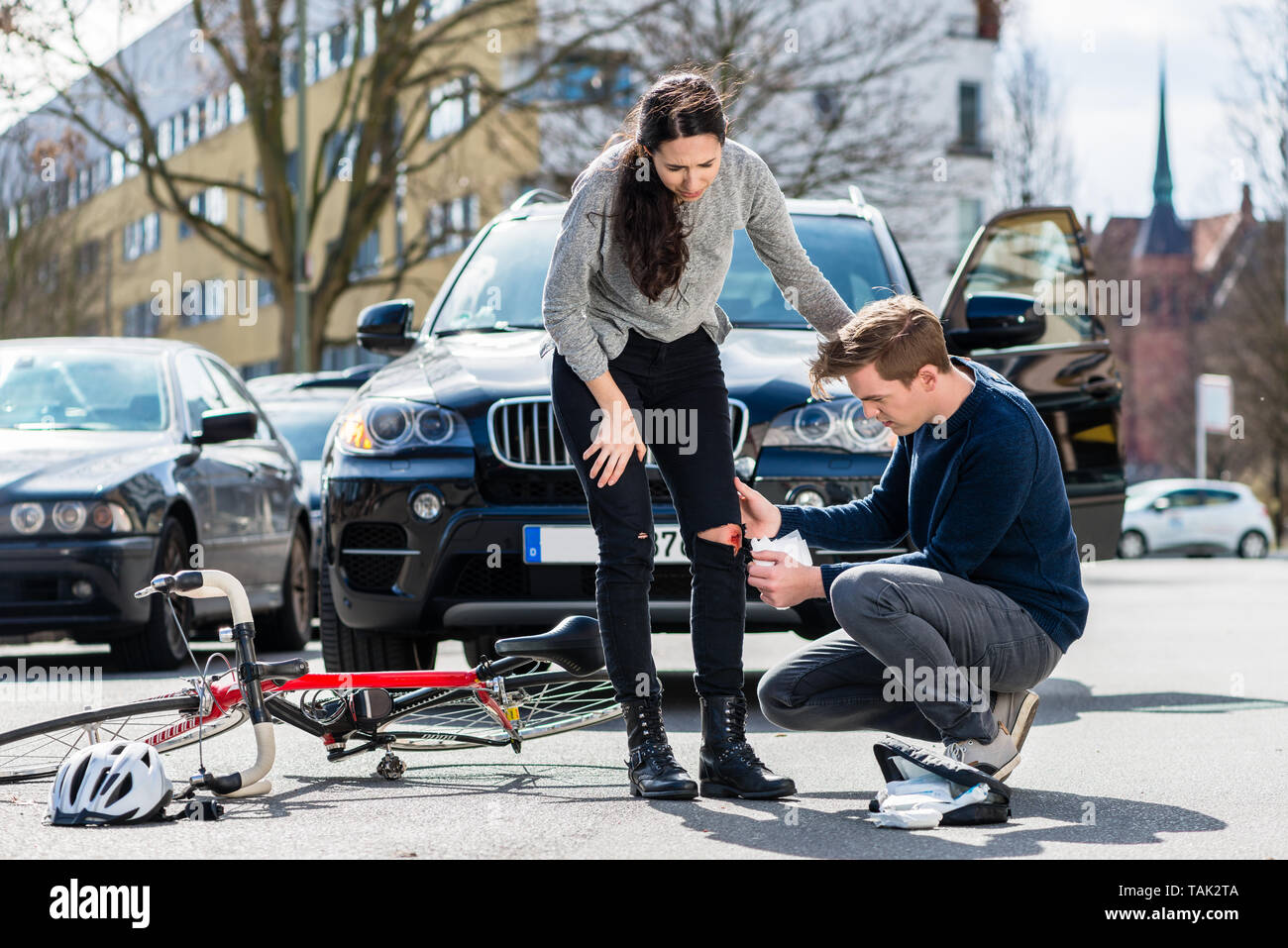 Young male driver using a sterile adhesive bandage from his first aid ...