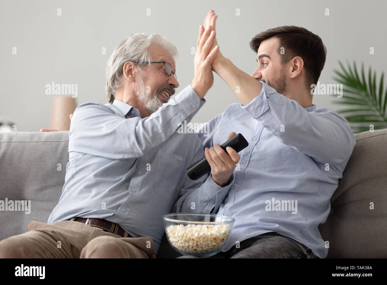 Happy father and son celebrate team win at home Stock Photo - Alamy