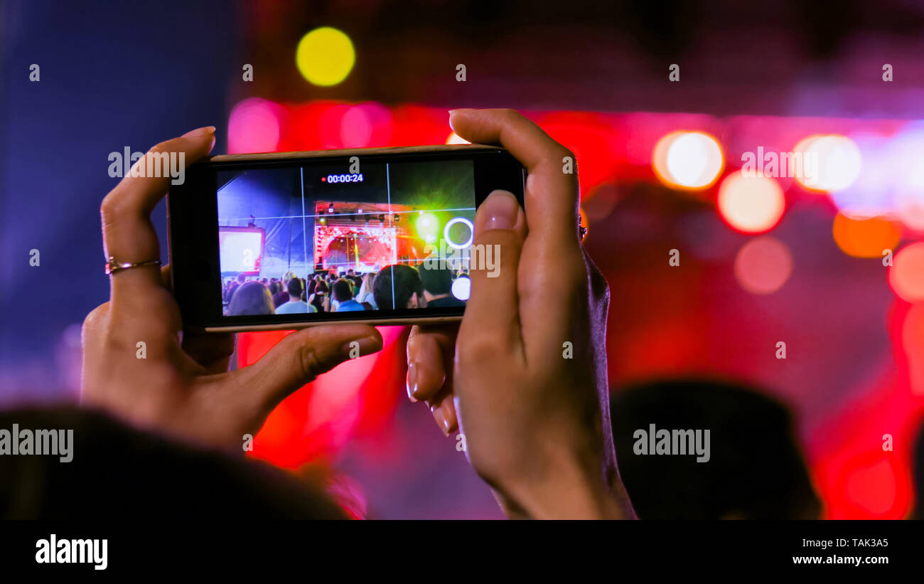 Woman hands silhouette recording video of live music concert with ...