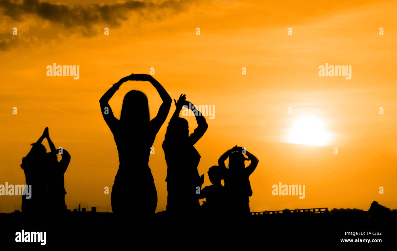 Women dancing at sunset Stock Photo - Alamy