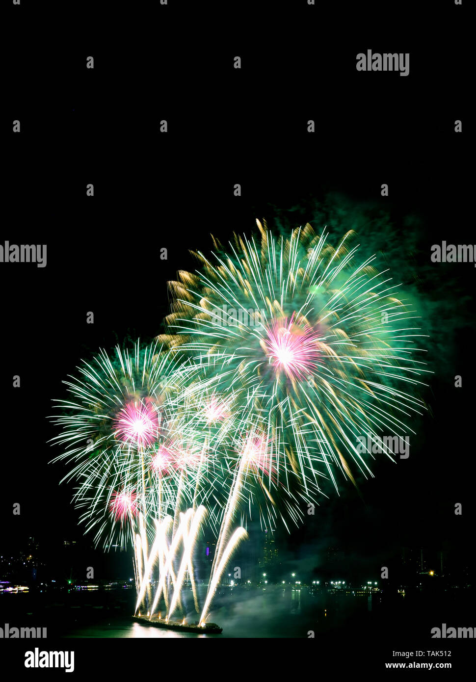 Vertical image of green and pink fireworks in the night sky Stock Photo ...