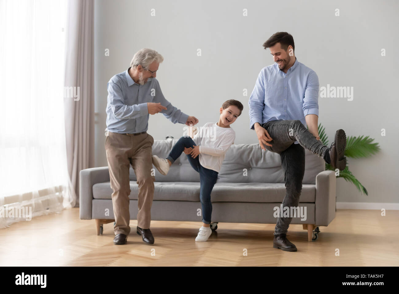 Happy three generations of men dancing together Stock Photo - Alamy