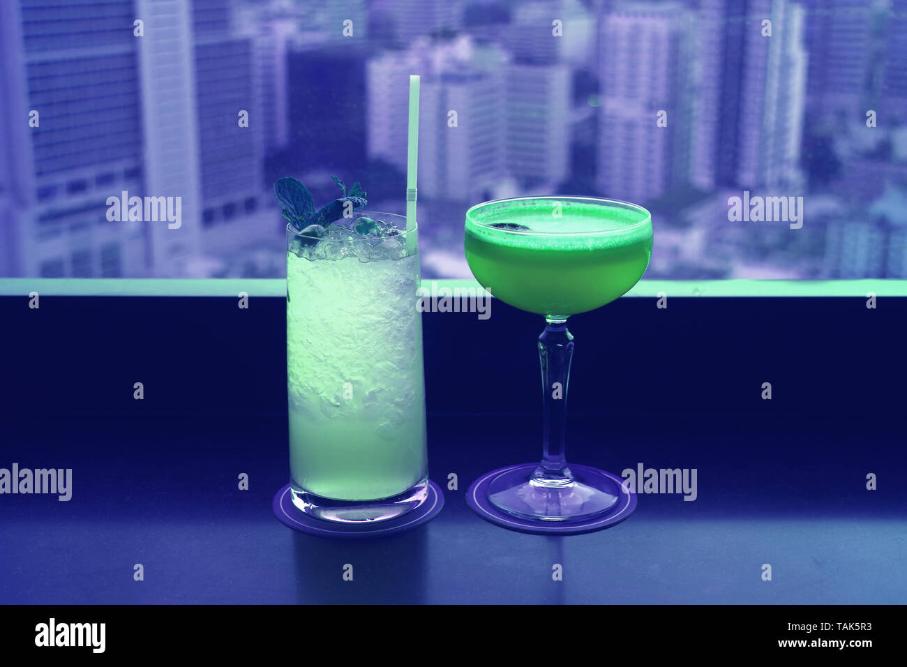 Two different type of cocktails in vibrant green color on the rooftop ...