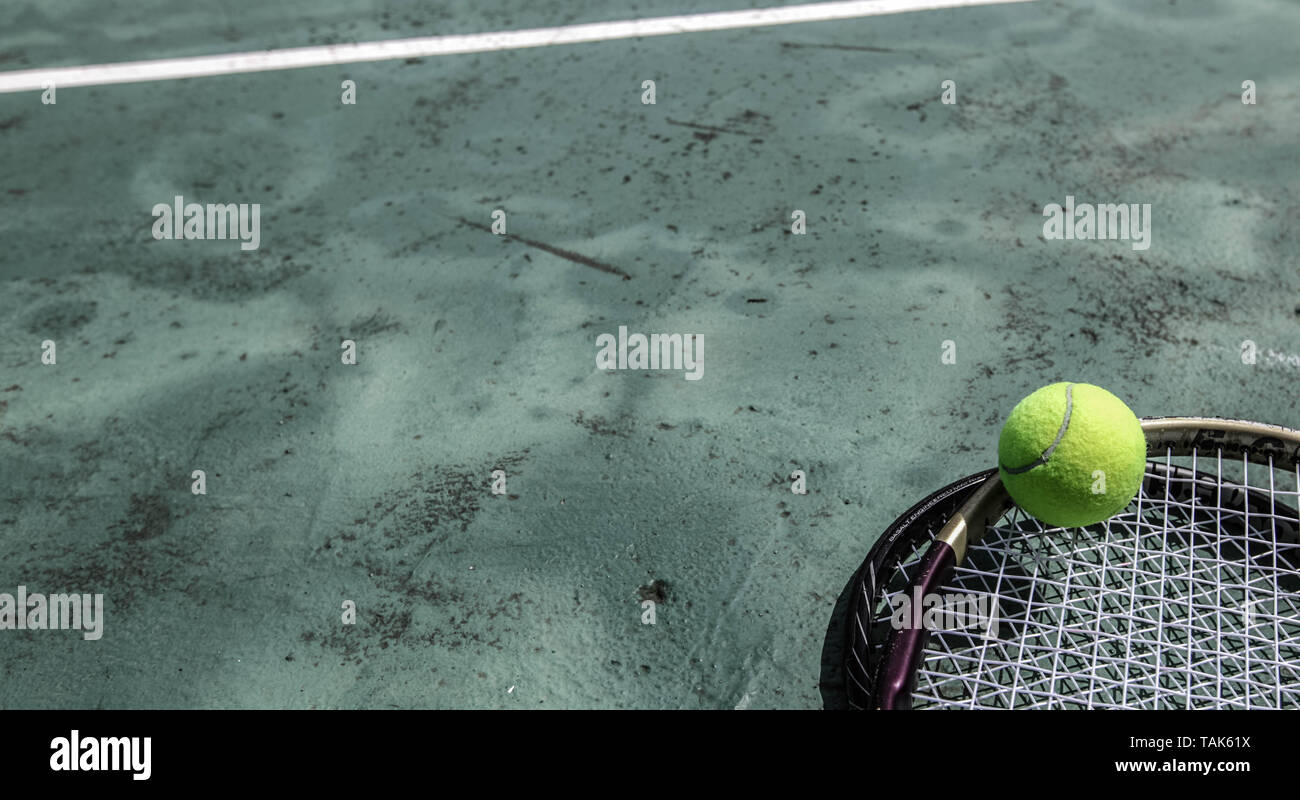Tennis ball and racket in outdoor tropical court Stock Photo - Alamy