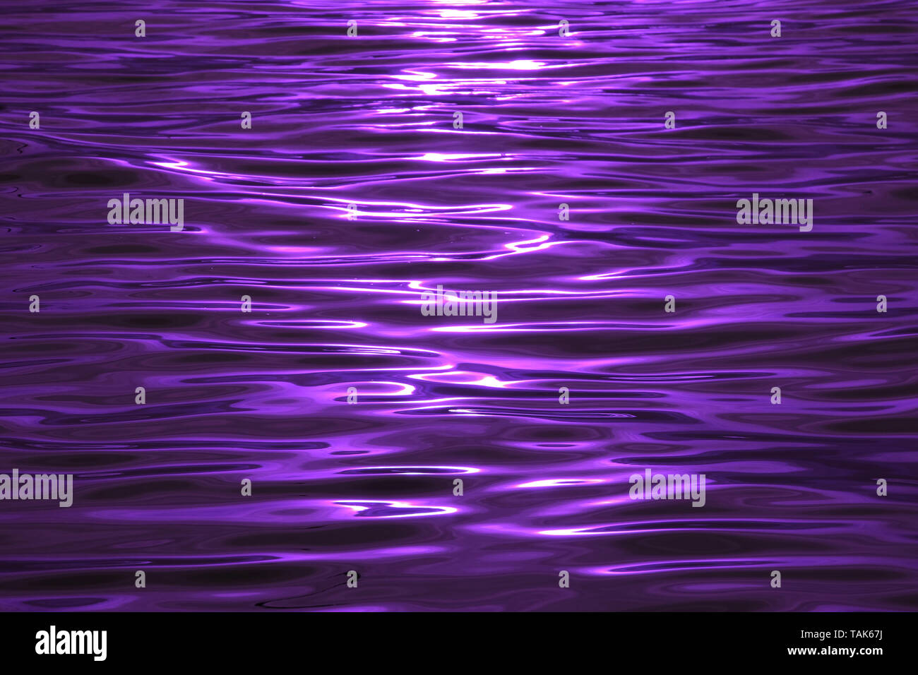 Sea ripples with sunlight reflections in purple color tone for ...