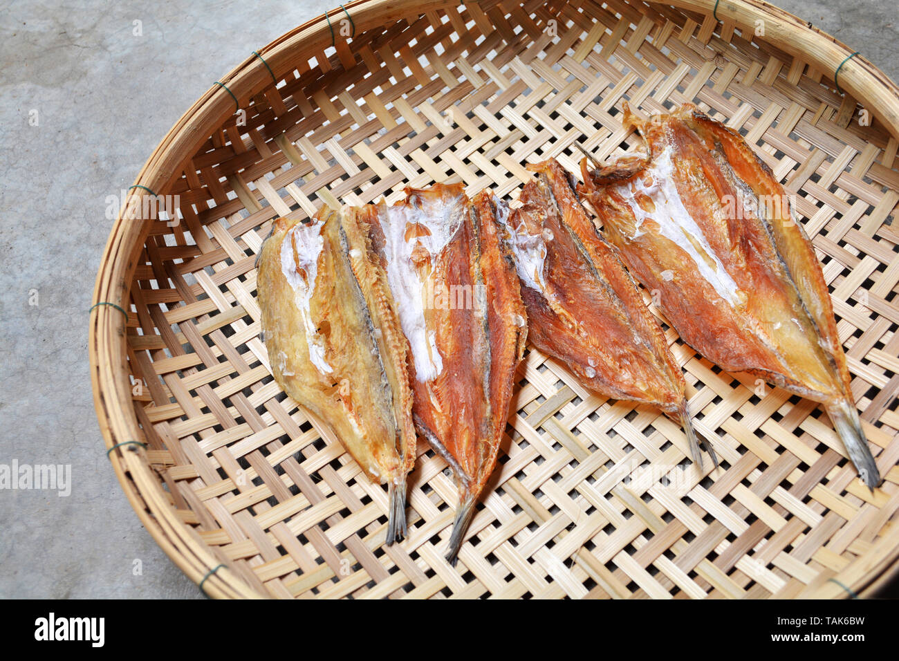 Making dried fish / dry salted fish on threshing basket background ...