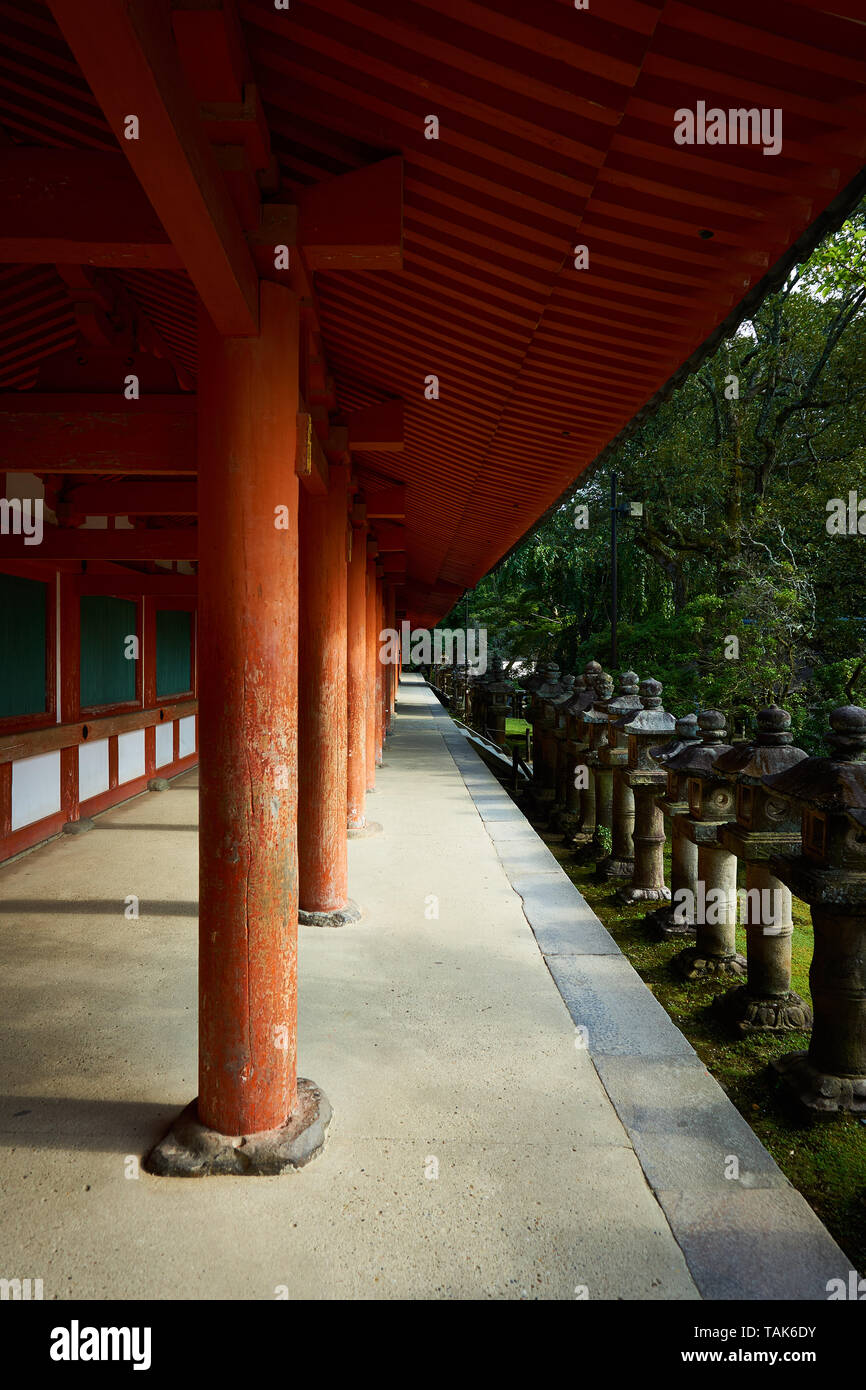 Vermillion columns and old stone lanterns line the veranda around the ...
