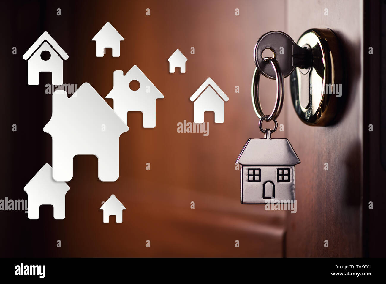 House key on a house shaped silver keyring in the lock of a door Stock ...