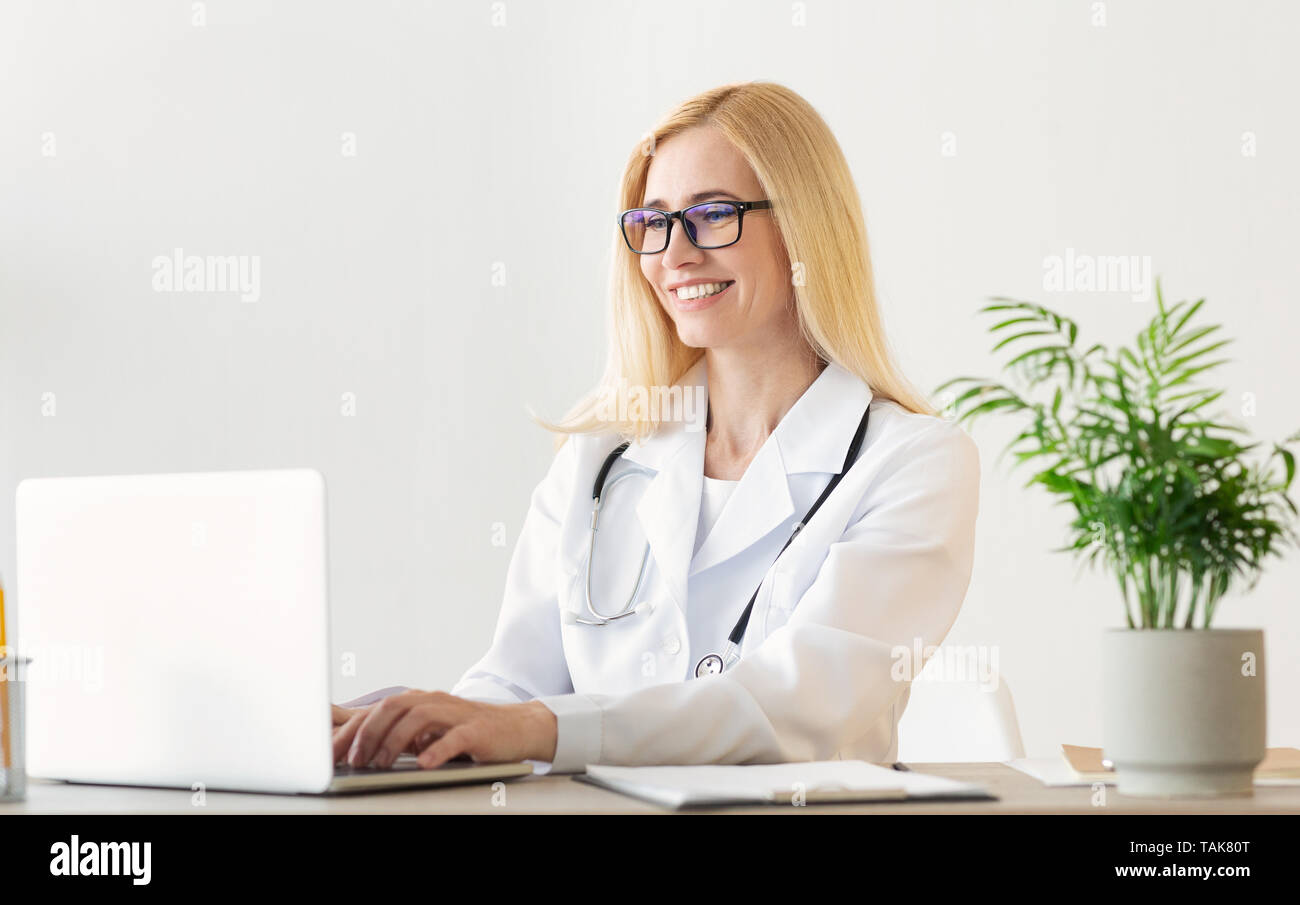 Happy Female Doctor Working On Laptop Computer Stock Photo - Alamy
