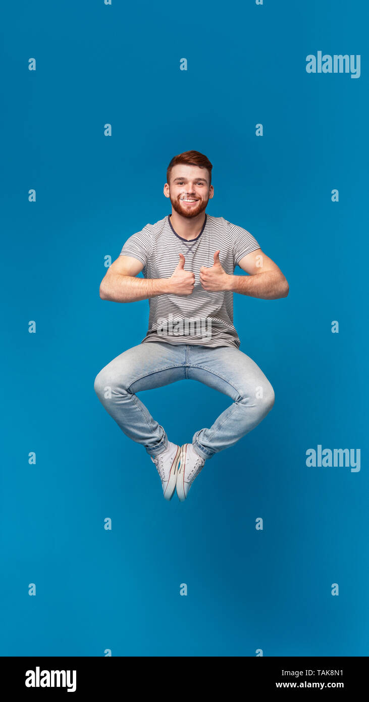 Joyful man jumping up in air, demonstrating thumbs up gesture Stock ...
