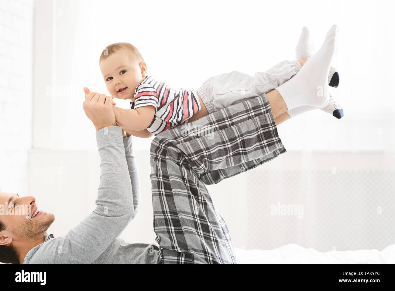 Happy father playing with adorable baby in bedroom Stock Photo - Alamy
