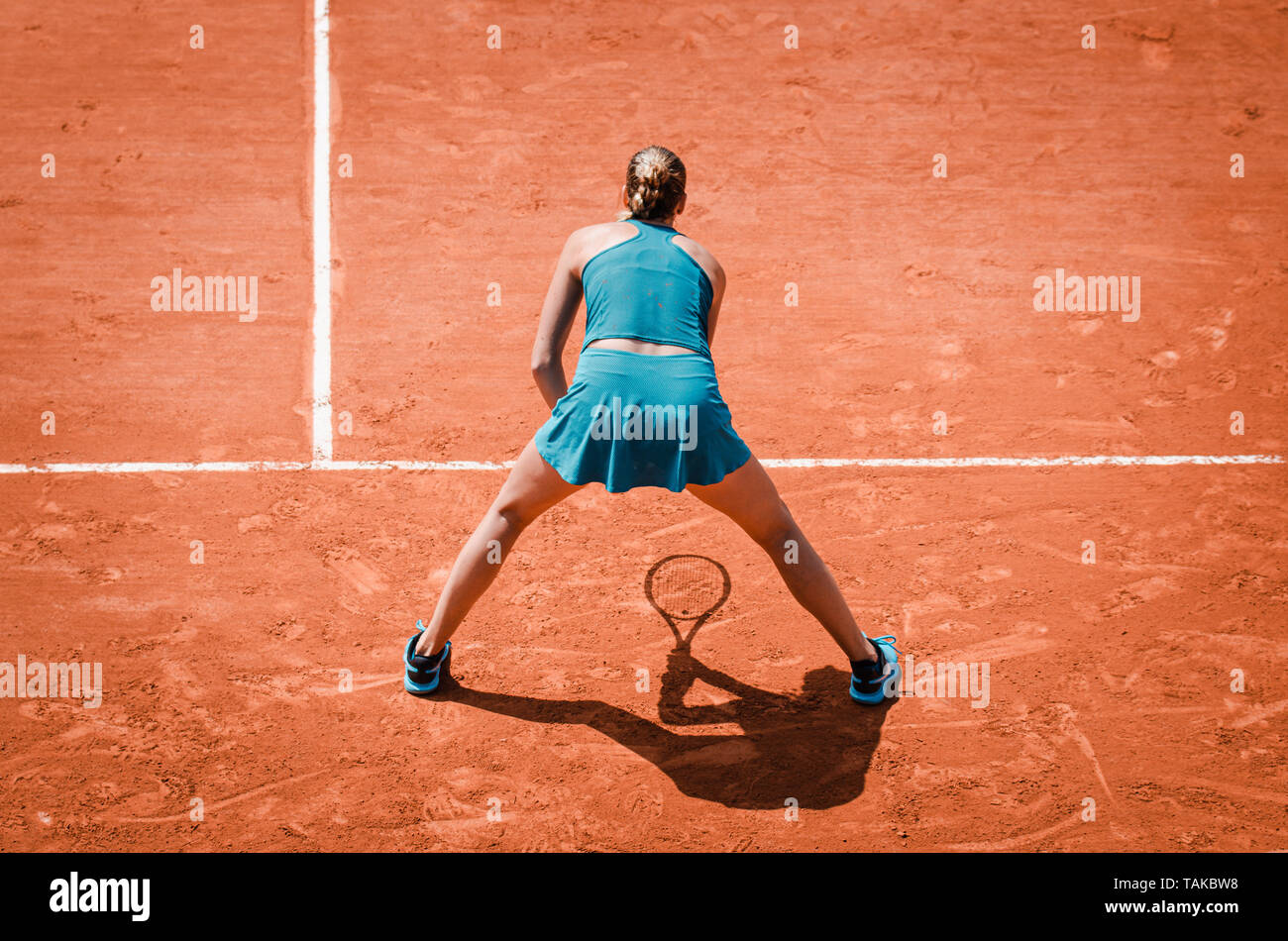 Back view of a woman playing tennis, waiting to receive service ...