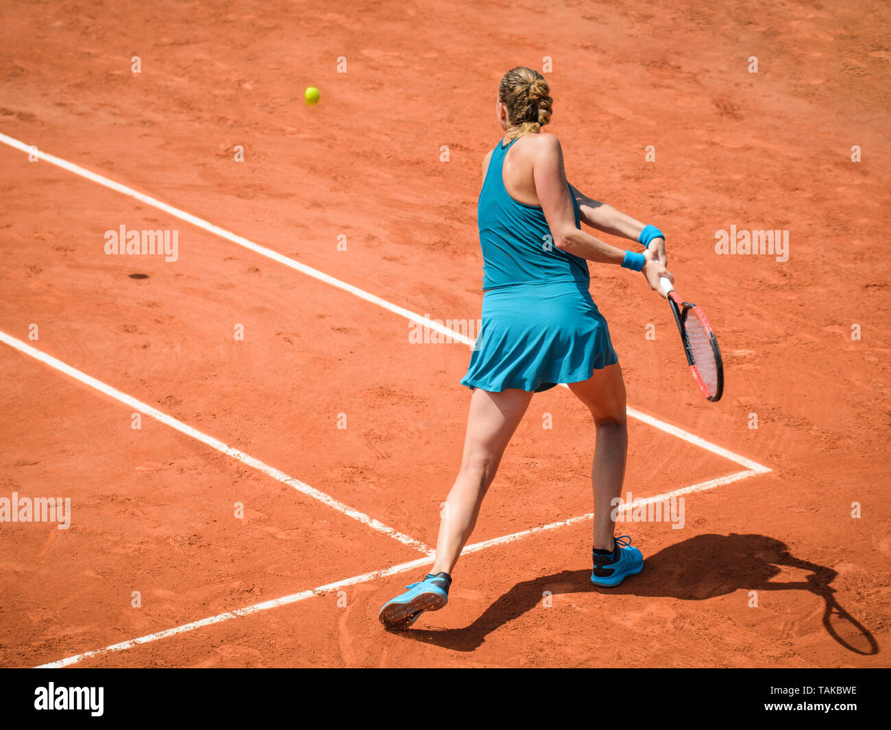 Back view of a woman playing backhand in tennis outdoor competition ...
