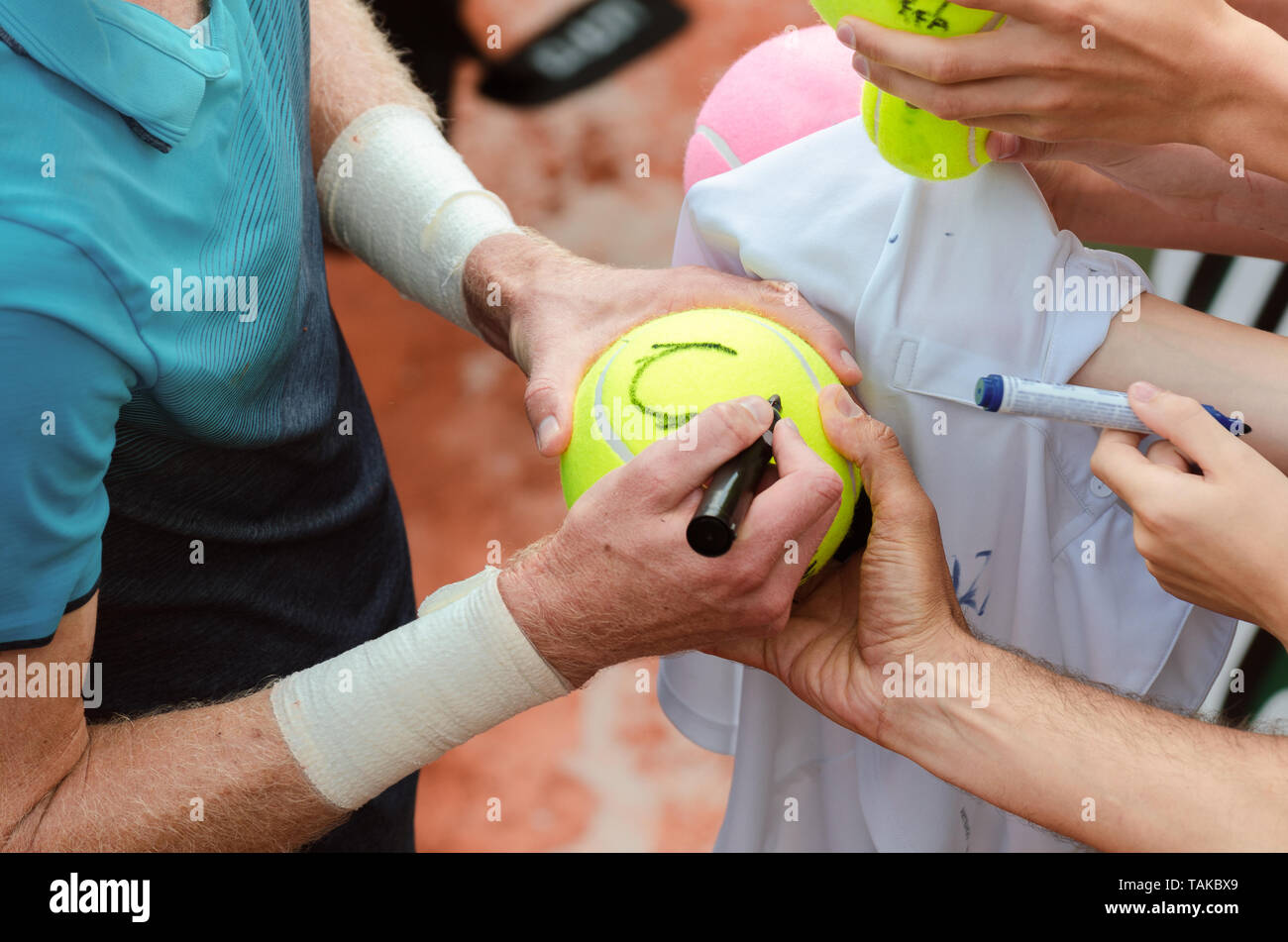 Tennis player signs autograph on a tennis ball after win, closeup photo ...