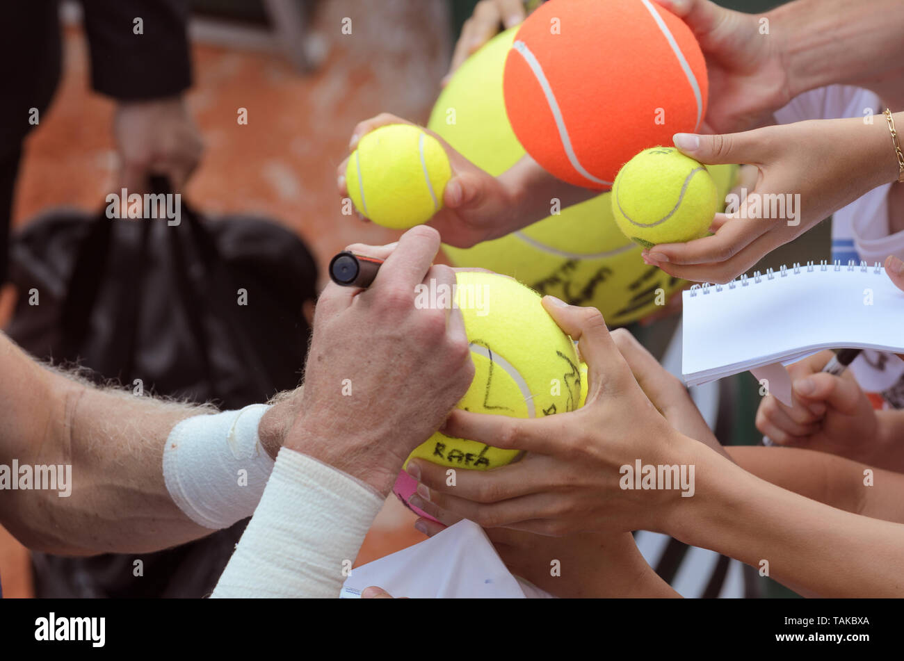 Tennis player signs autograph on a tennis ball after win, closeup photo ...