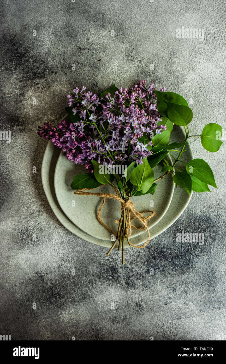 Spring table setting with beautiful lilac flowers on grey concrete ...