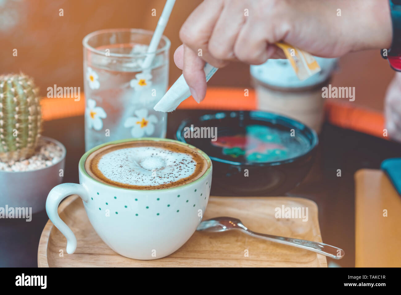 Woman pouring sugar into a white cup of coffee, Selective focus on ...