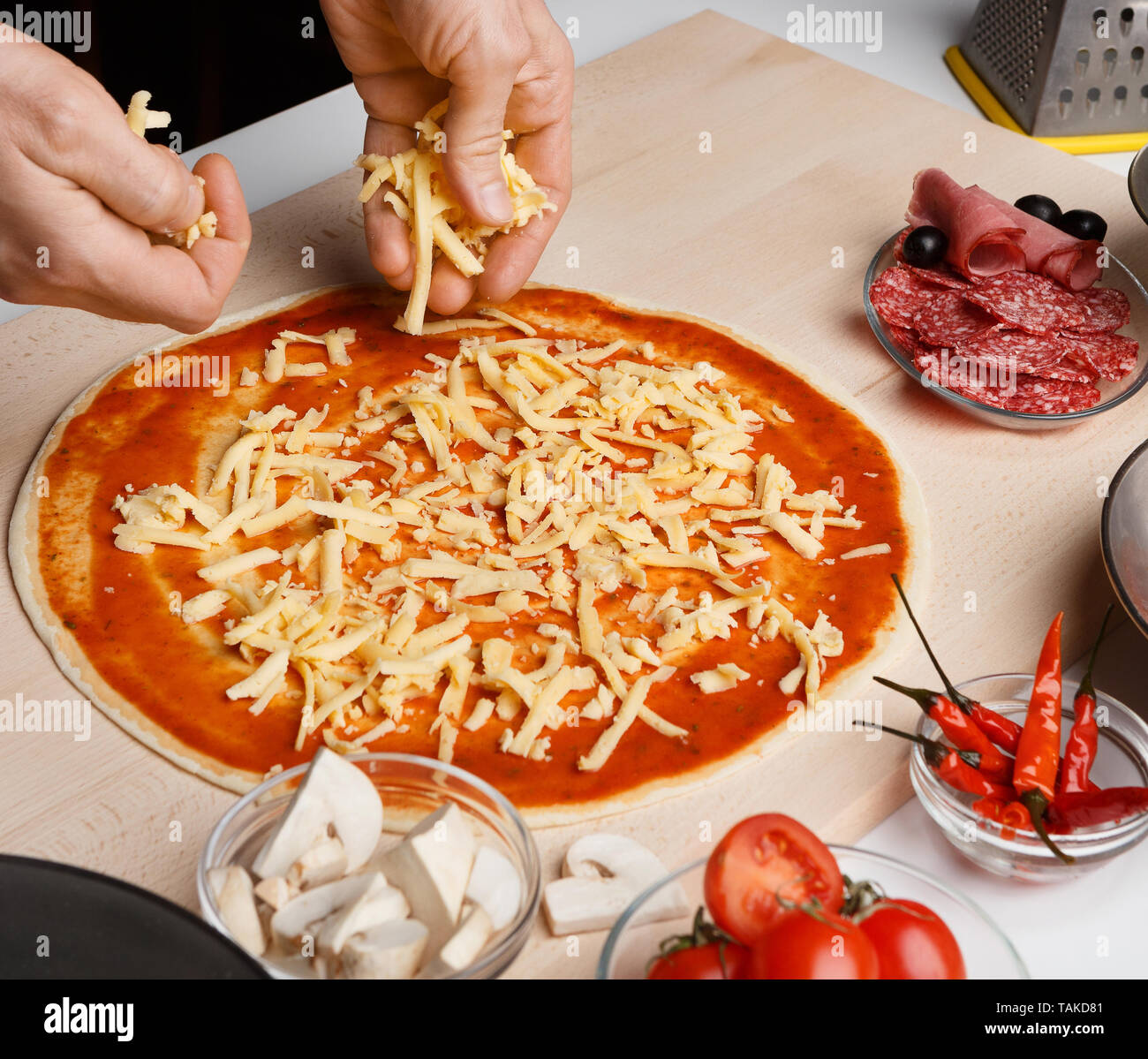 Chef Spreading Cheese Toppings On Pizza Base Stock Photo - Alamy