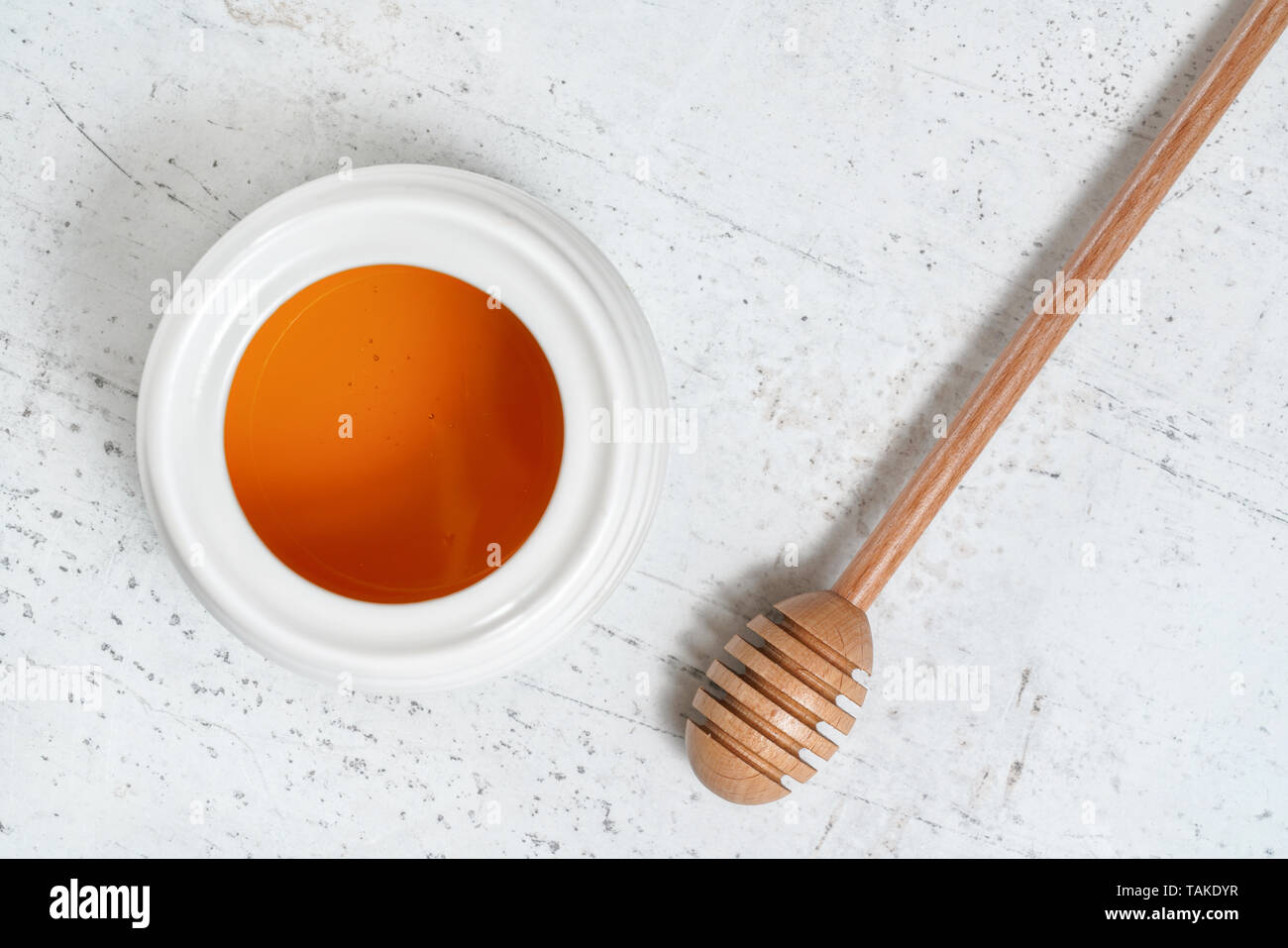 Top down view, honey dipper and white porcelain pot on stone desk Stock ...