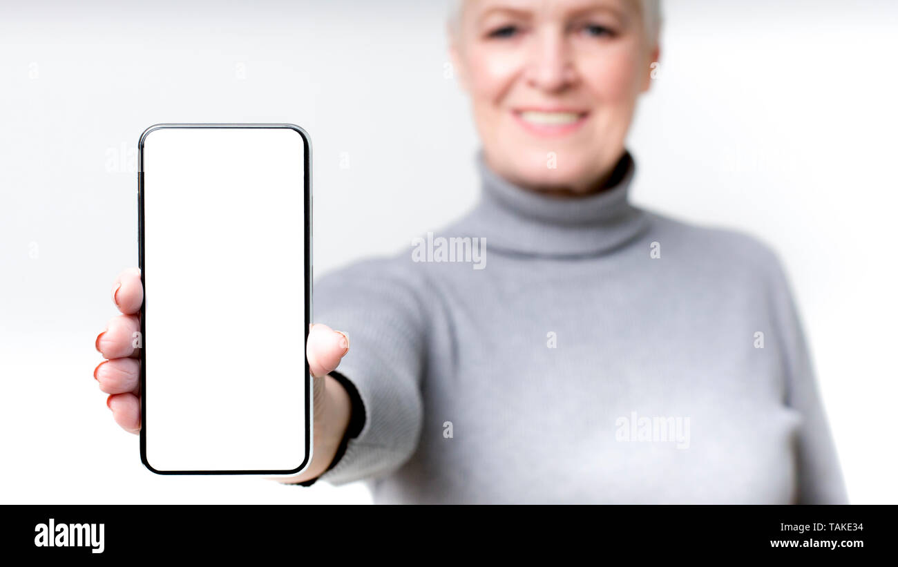 Joyful mature lady showing cellphone with blank screen Stock Photo - Alamy