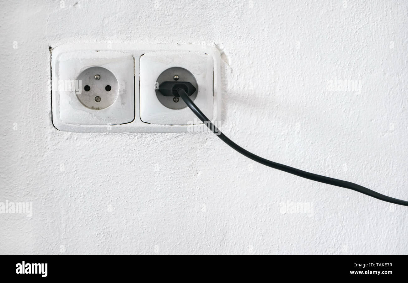 Rough facade white wall with two european style power outlet, one ...