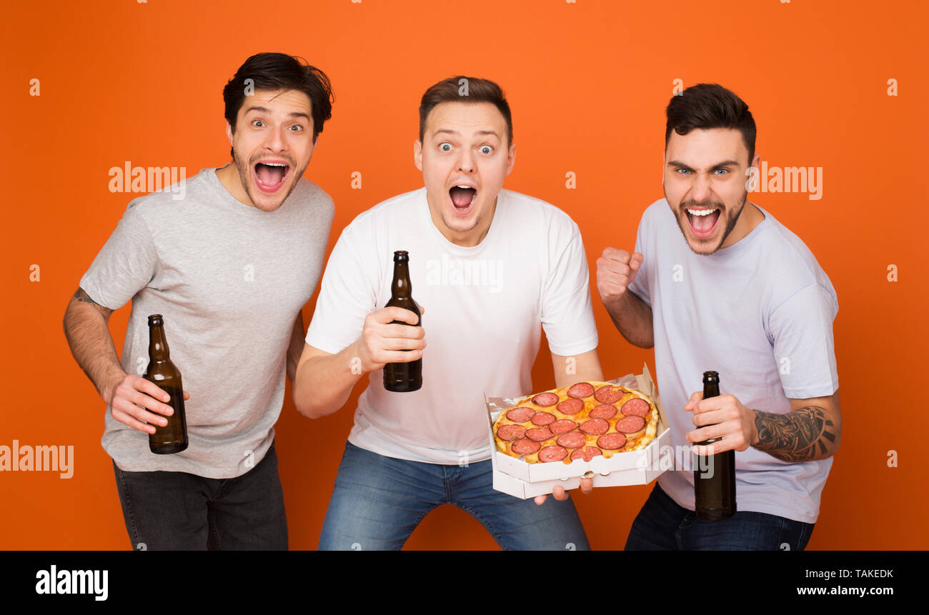 Excited Friends Drinking Beer And Eating Pizza, Orange Background Stock ...